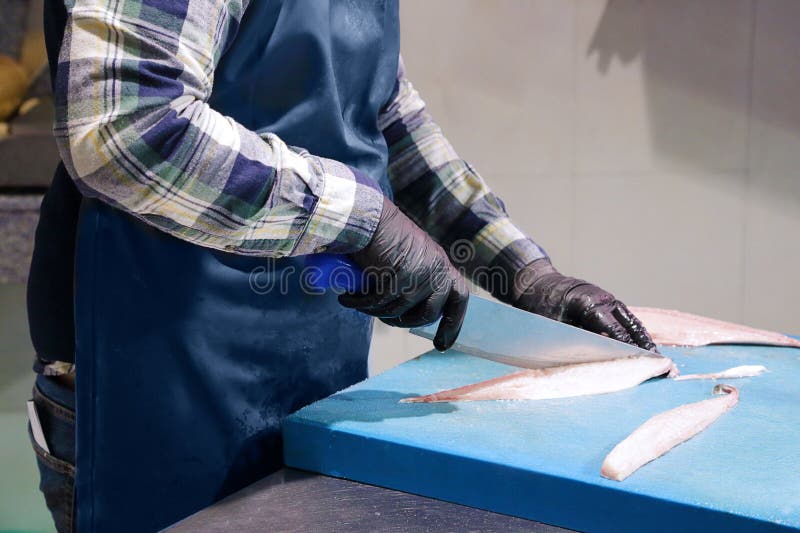 Fishmonger cutting fish stock photo. Image of glove - 376141204