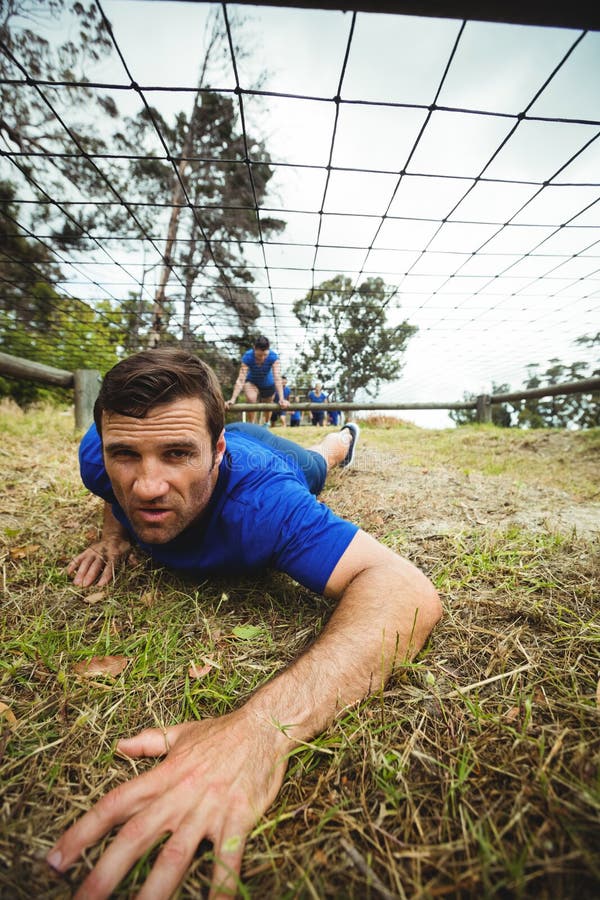 Fit Man Crawling Under the Net during Obstacle Course Stock Image ...