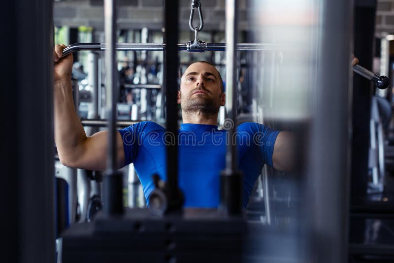 Fit Man Exercising at the Gym on a Machine. Stock Image - Image of ...