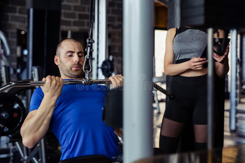 Fit Man Exercising at the Gym on a Machine. Stock Photo - Image of ...