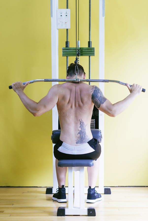 Fit Man on Lat Pull Down Machine at the Health Club. Work Out on Pull ...