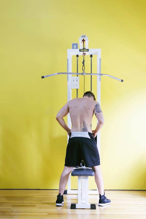 Fit Man on Lat Pull Down Machine at the Health Club. Work Out on Pull ...