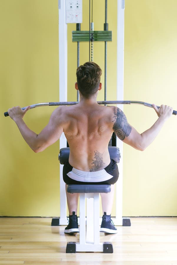 Fit Man on Lat Pull Down Machine at the Health Club. Work Out on Pull ...