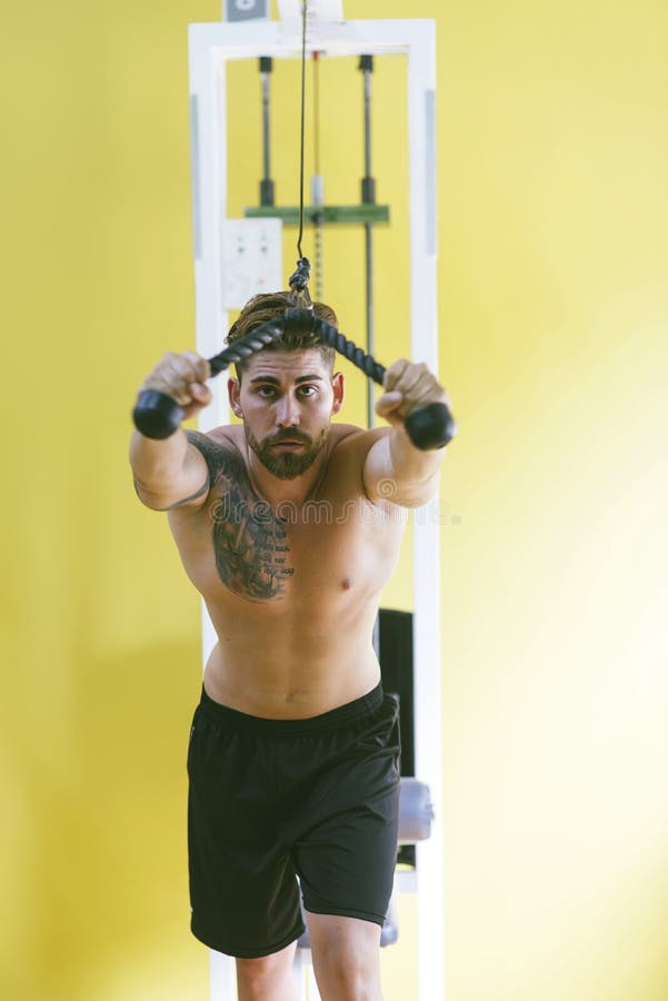 Fit Man on Lat Pull Down Machine at the Health Club. Work Out on Pull ...