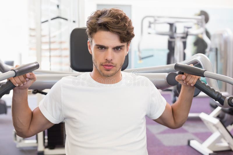 Fit Man Using Weights Machine for Arms Looking at Camera Stock Photo ...