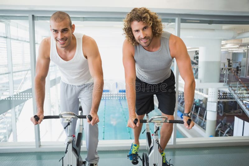 Fit Men Working on Exercise Bikes at Gym Stock Photo - Image of sporty ...