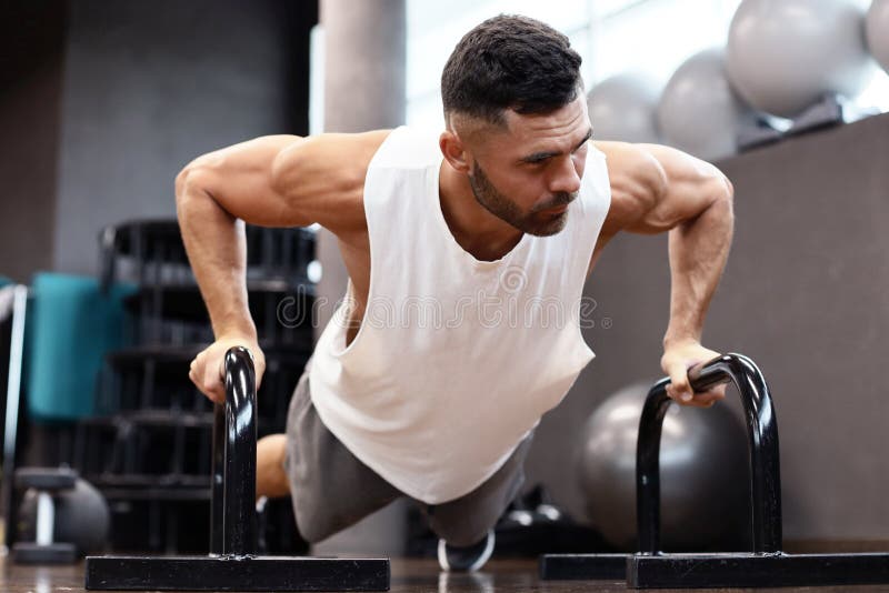 Fit And Muscular Man Doing Horizontal Push-ups With Bars In Gym Stock ...