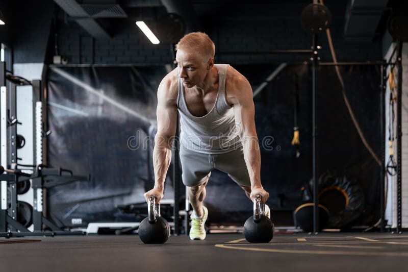 Fit and Muscular Man Doing Horizontal Push-ups on Dumbbells in Gym ...