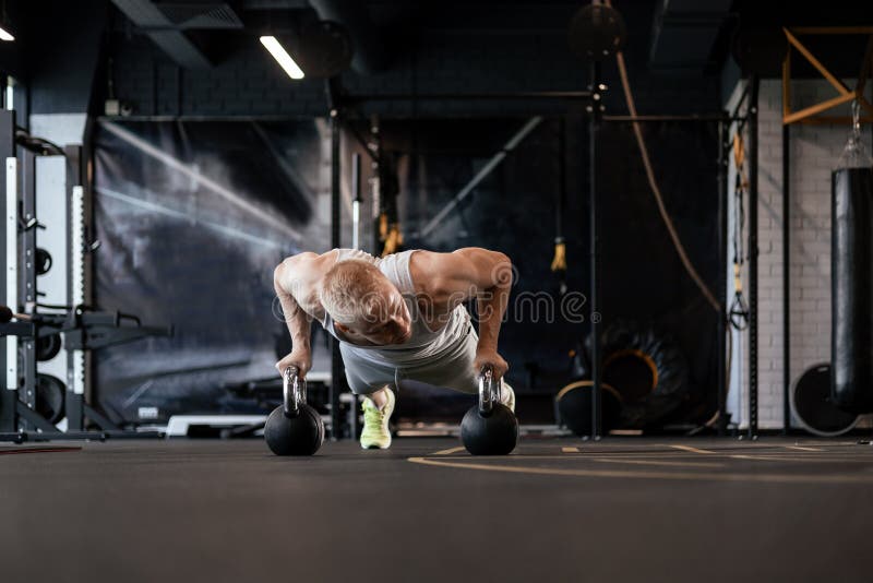 Fit and Muscular Man Doing Horizontal Push-ups on Dumbbells in Gym ...