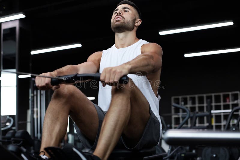 Fit and Muscular Man Using Rowing Machine at Gym Stock Photo - Image of ...