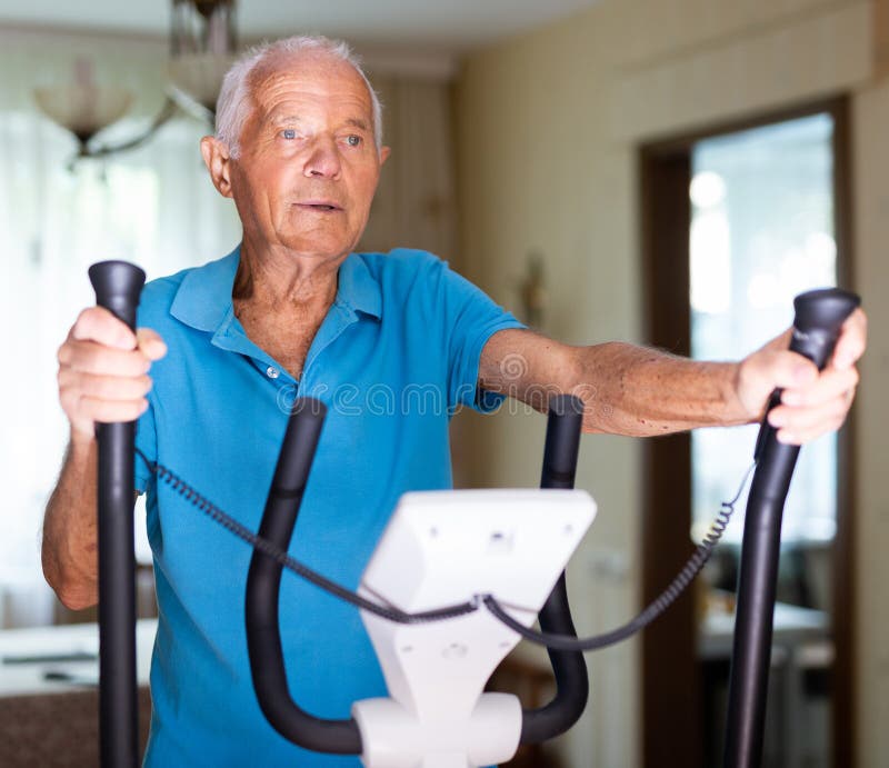 Fit Senior Man at Home Doing Cardio Work Out on an Elliptical Machine ...
