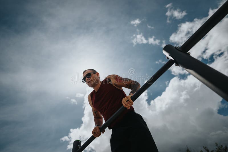 Fit Man Doing Pull-ups at an Outdoor Park Gym on a Clear, Sunny Day ...