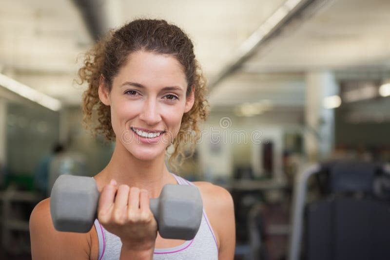 Fit Woman Smiling at Camera Lifting Dumbbell Stock Photo - Image of ...