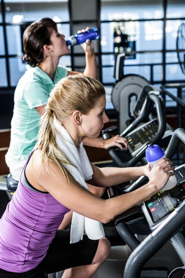 Fit Women Doing Exercise Bike Stock Image - Image of female, drinking ...