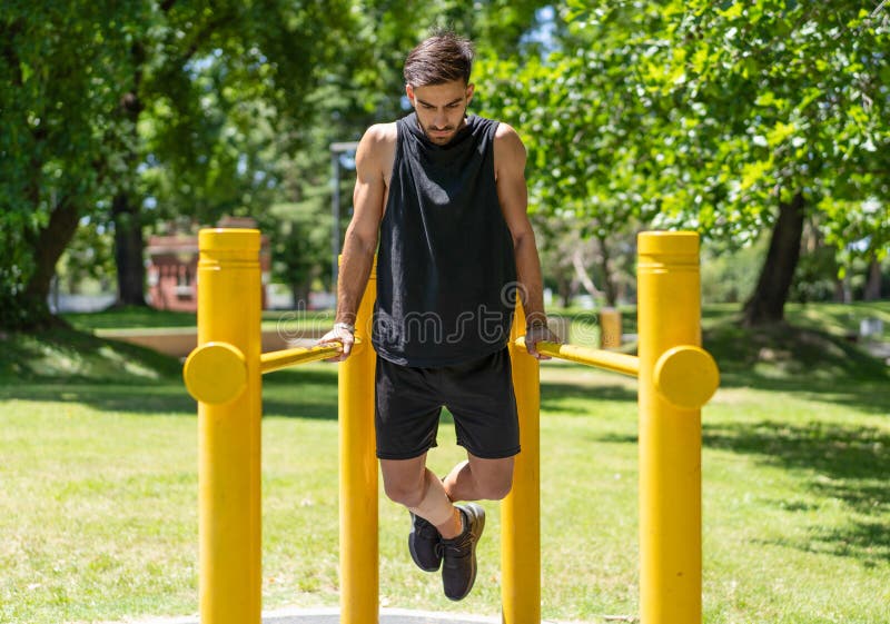 Fit Young Man Executing Dips on Outdoor Parallel Bars in the Park Stock ...