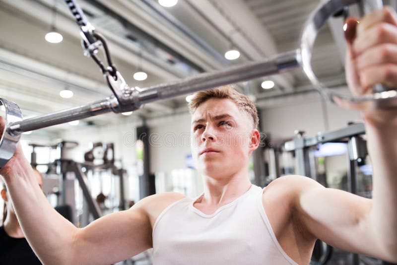 Fit Young Man in Gym Working Out on Pull-down Machine. Stock Photo ...