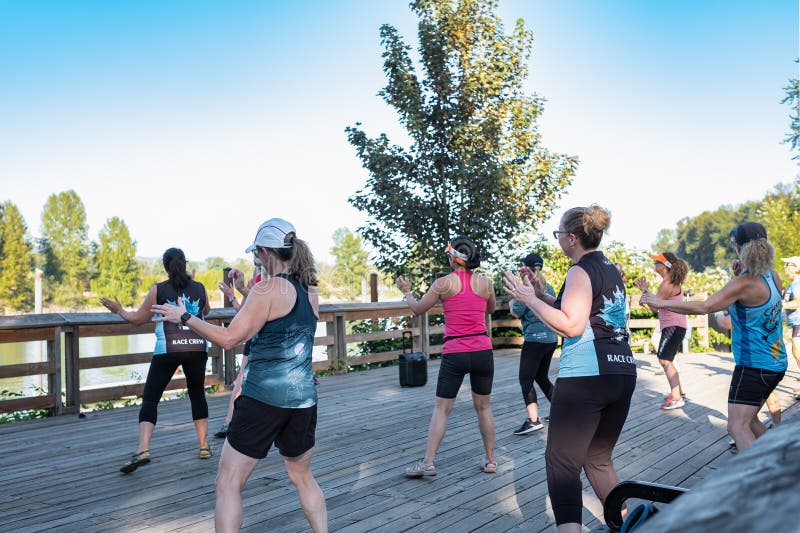Fitness Class with Instructor Doing Exercise in Park. Group of Fit and ...
