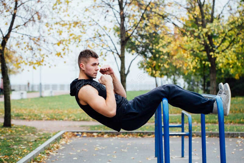 Fitness Man Doing Stomach Workouts on Horizontal Bar Outdoors Stock ...