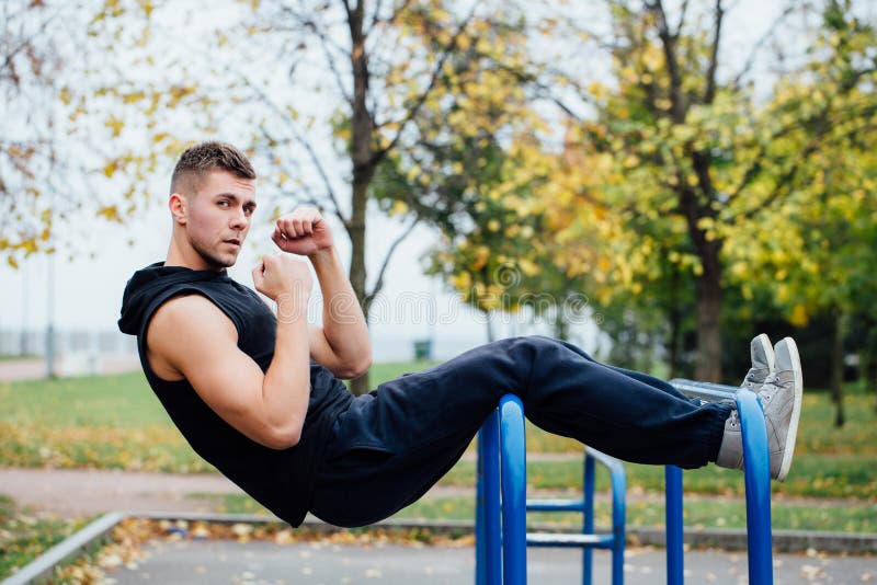 Fitness Man Doing Stomach Workouts on Horizontal Bar Outdoors Stock ...