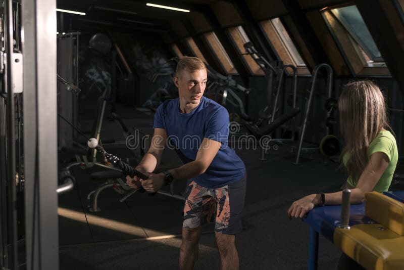 Fitness Trainer Conducts Personal Training in Gym. Athletic Guy Shows ...