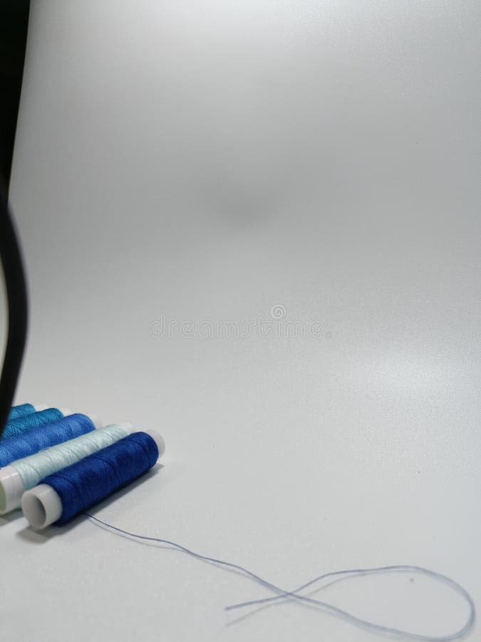 Blue Sewing Thread Spools with Unraveled Thread on White Background ...