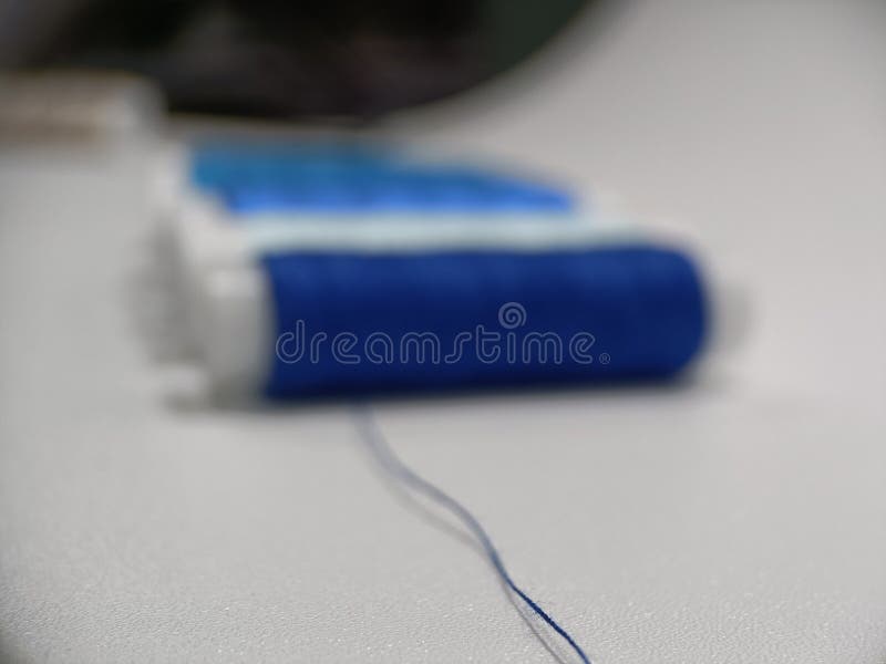 Blue Sewing Thread Spools with Unraveled Thread on White Background ...