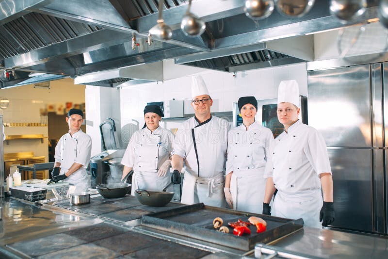 Five Chefs Wearing Uniforms Posing in a Kitchen. Stock Image - Image of ...
