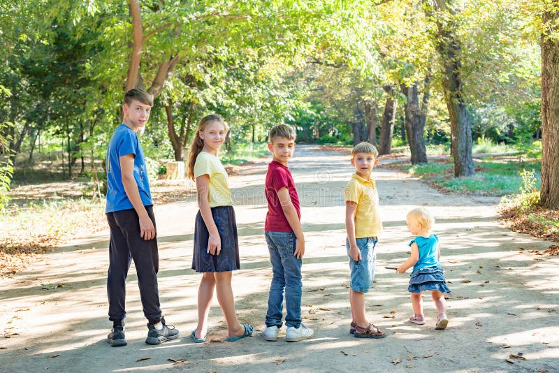 Five Children Stand in a Row in Height in the Park, Walking and Stock ...