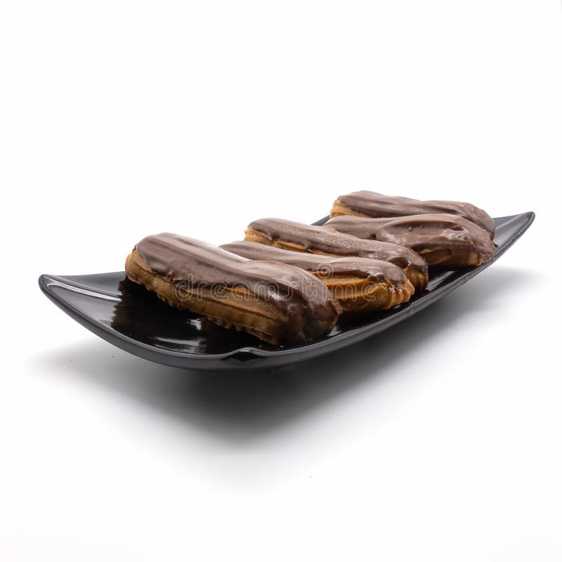 Five Chocolate-coated Eclairs on a Rectangular Black Platter. Stock ...