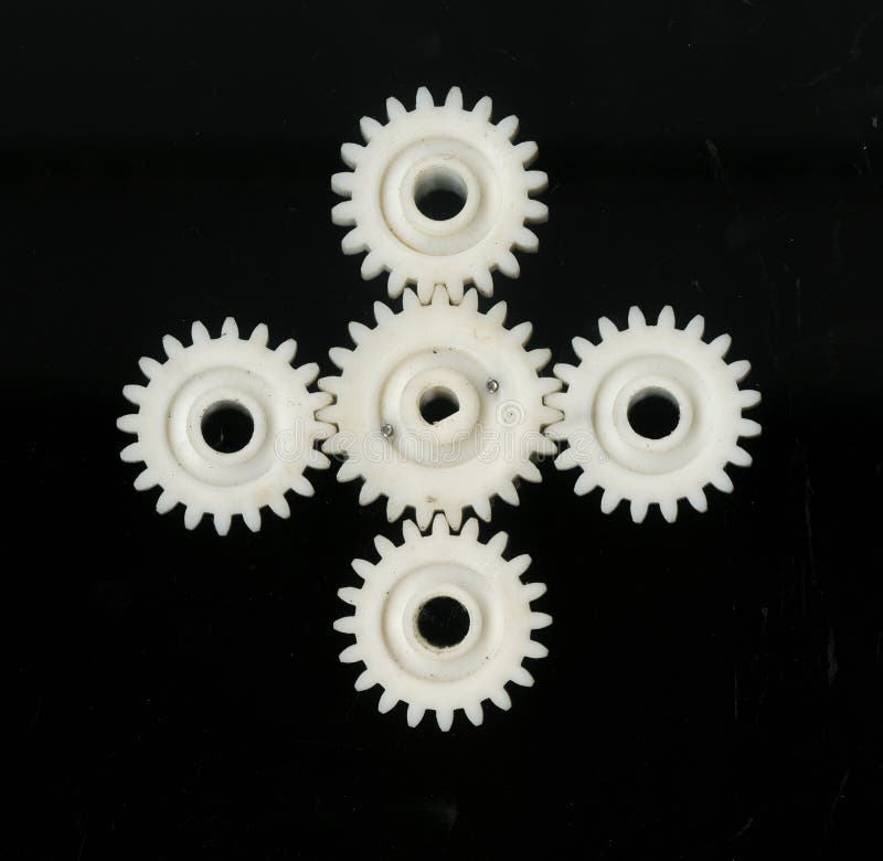 Three Concatenated White Plastic Toothed Gears of Different Sizes on a ...