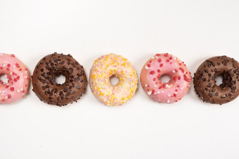 Five Donuts in a Row - White, Pink and Chocolate on a White Background ...