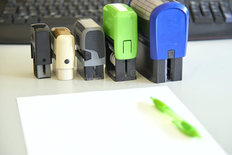 Five Handle Automatic Stamps, Sheet of Paper and Pen on a Desk Stock ...