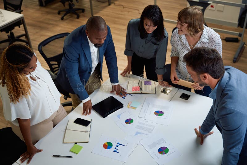 Five Happy Multiracial Business People Reviewing Graph Documents on ...