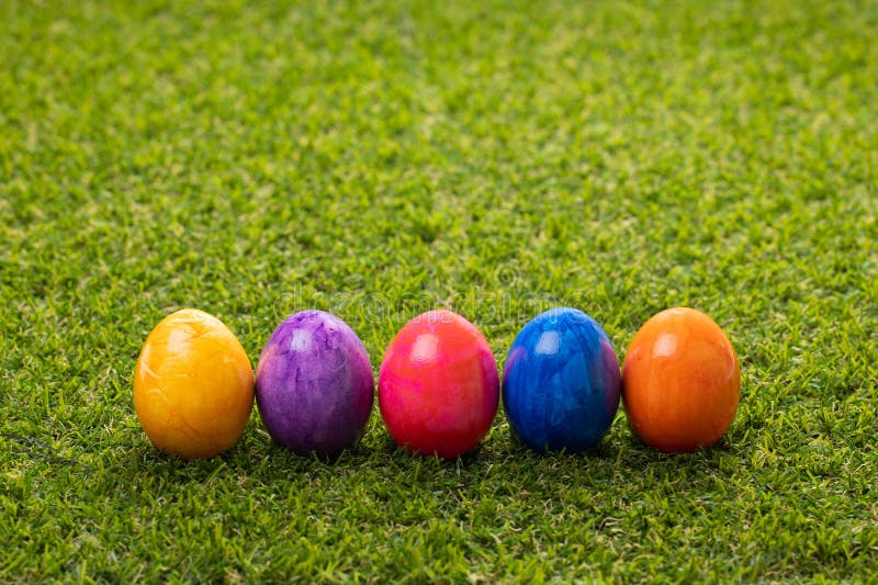 Five Multi-colored Easter Eggs Stand in a Row on the Lawn Stock Photo ...