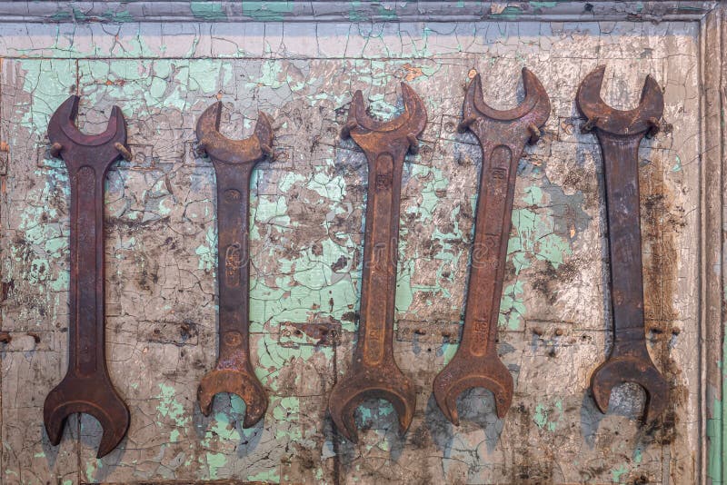 Five Old, Rusted Wrench Tools Hanging on Nails on Cracked, Damaged Wall ...