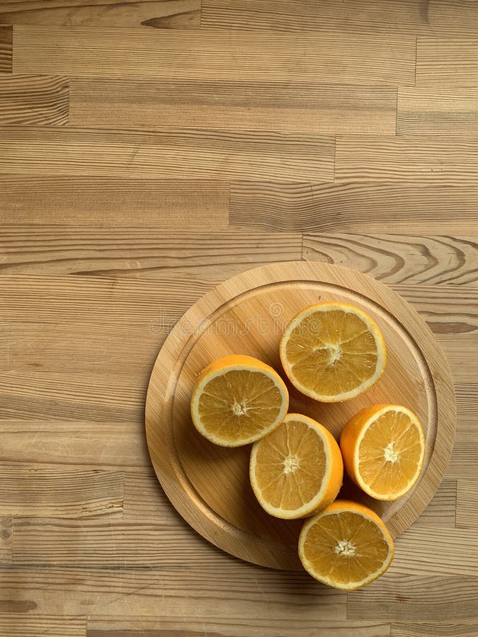 Five Orange Halves on a Round Wooden Authentic Board on a Wooden Table ...