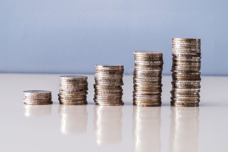 Five Piles of Vintage Coins Creating a Rising Chart on a Mirrored ...