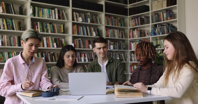 Five Students Talking Seated at Table with Books and Laptop Stock Video ...
