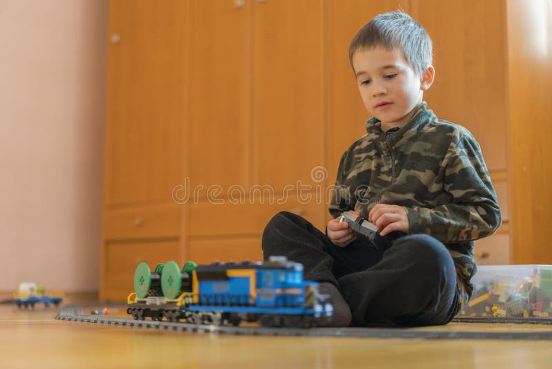 Five Year Old Boy Playing on the Floor by Rail. Little Boy Playing with ...