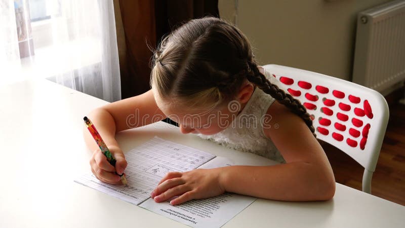 Five Year Old Girl Studying a Spelling Sitting at a Table in a White ...