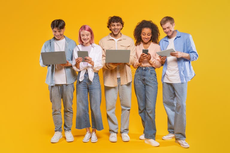 Five Diverse Young Adults Using Technology in Front of Yellow Stock ...