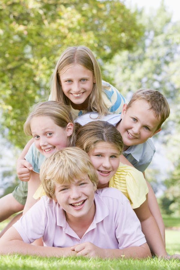 Five Young Friends Piled on Each Other Outdoors Stock Photo - Image of ...