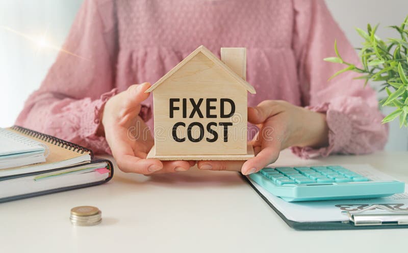 Fixed Cost Text on Wooden House Figurine in Hands and Office Tools ...