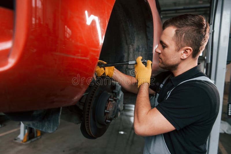 Fixing Breaks. Man in Uniform is Working in the Auto Service Stock ...