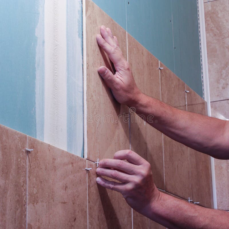 Fixing tiles to the wall. stock photo. Image of interior - 64282110