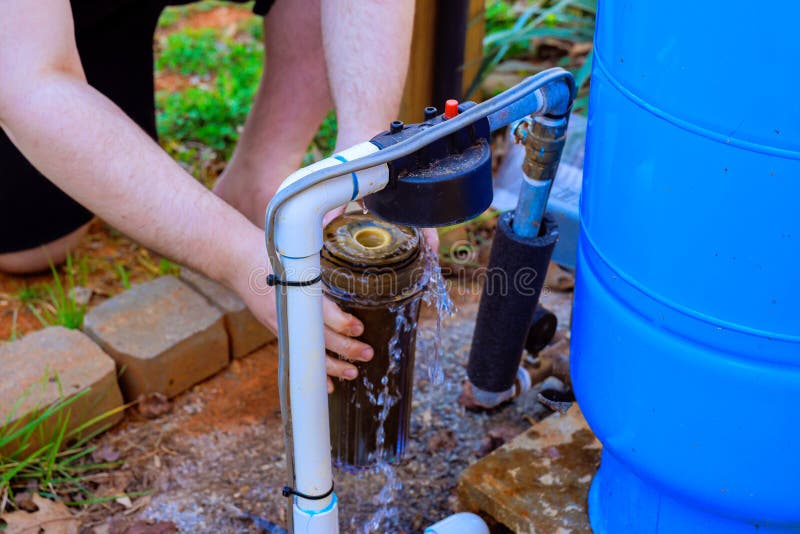 Fixing a Water Pump in a Backyard during the Afternoon Sunlight for ...