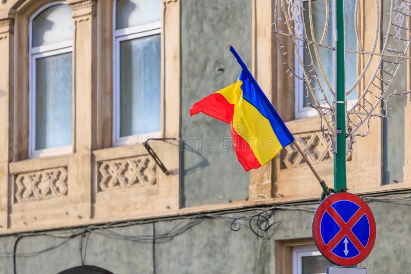 A Flag is Flying on a Pole in Front of a Building, Romanian Flag of the ...