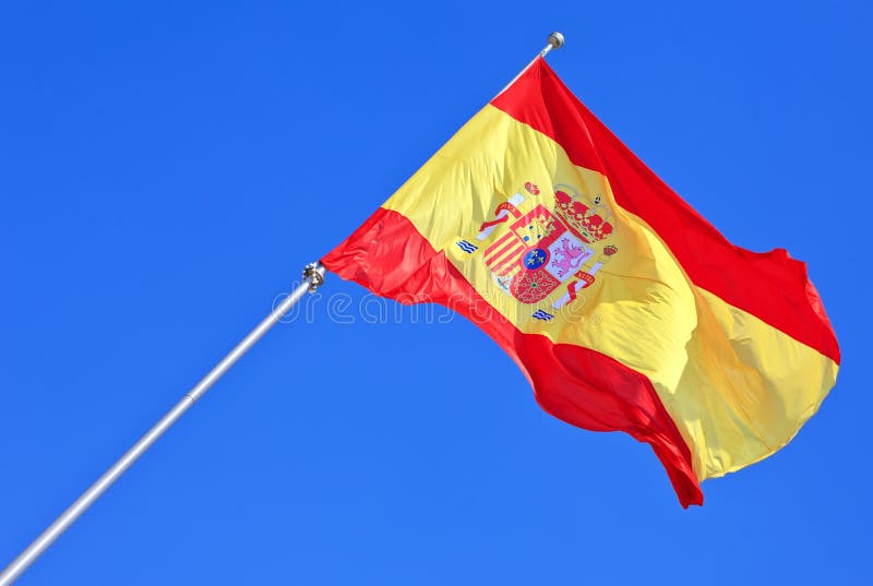 Flag of Spain Flying in the Wind Against a Blue Sky Stock Photo - Image ...