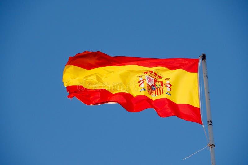 Flag of Spain Hung on a Pole in the Background of a Blue Sky. Stock ...
