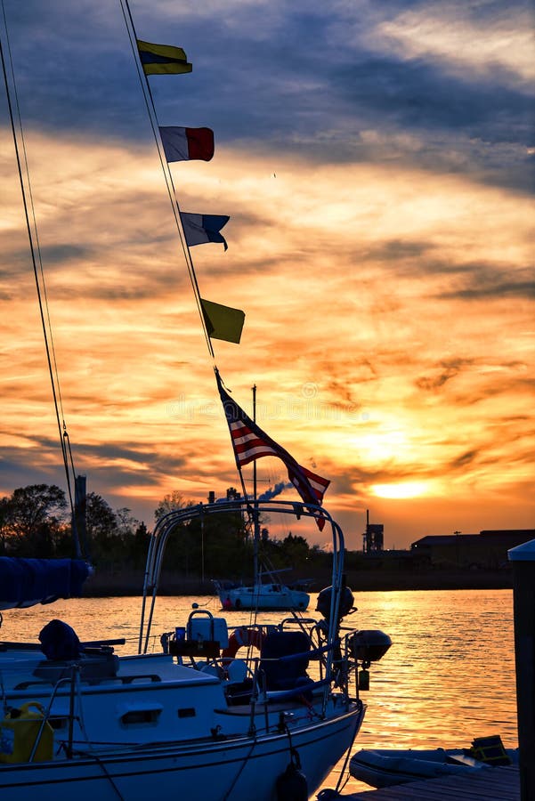 Flags on a Sailboat Silhouetted by the Setting Sun. Stock Image - Image ...